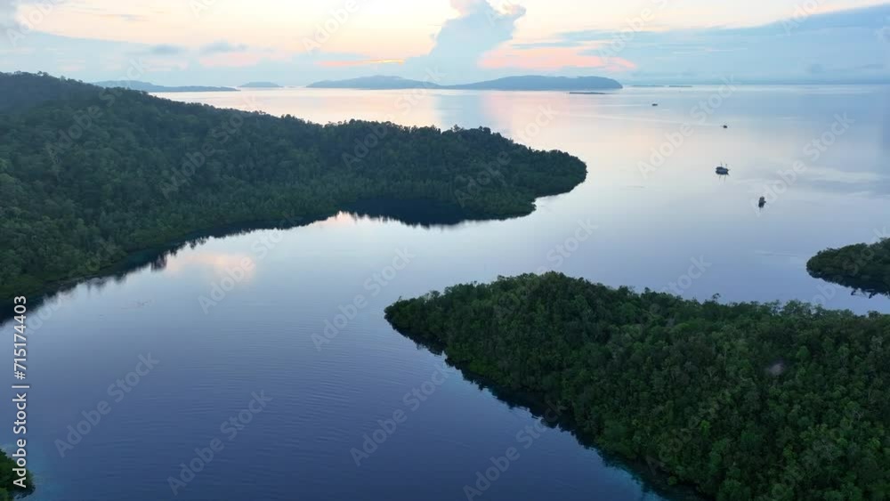 Sunrise illuminates calm seas around the islands of Gam and Yangeffo in ...