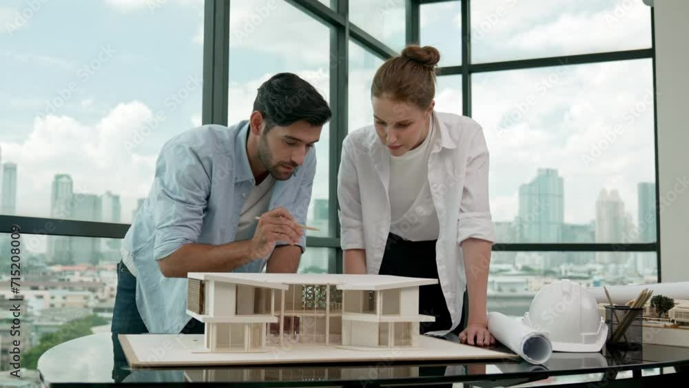 Skilled project manager pointing architectural model by using pencil ...