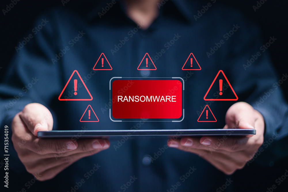 Malware attack virus alert. Person use tablet with virtual warning sign ...