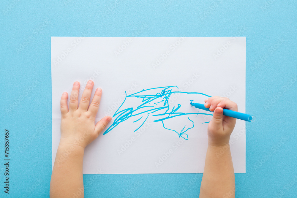 Baby boy hand holding marker and drawing first scratches lines on white ...