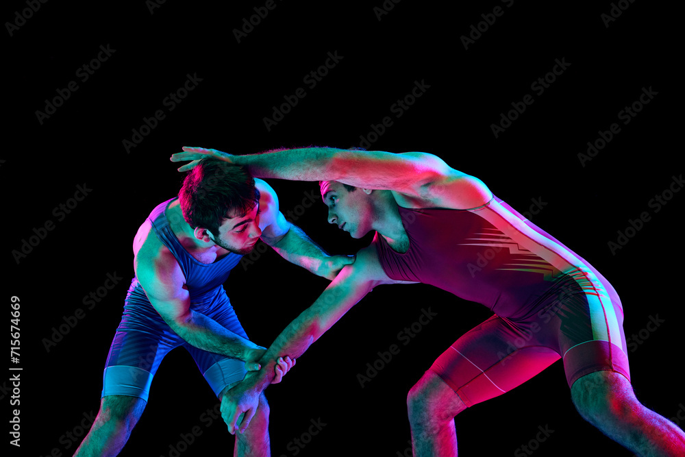 Young skilled wrestlers in blue and red uniform hand fighting in ...