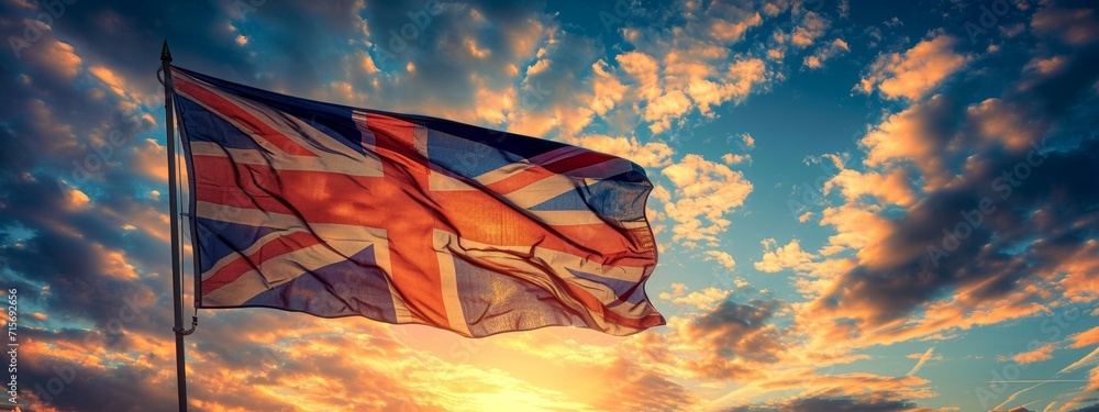 The Union Jack flag billowing in the warm glow of a sunset, signifying ...