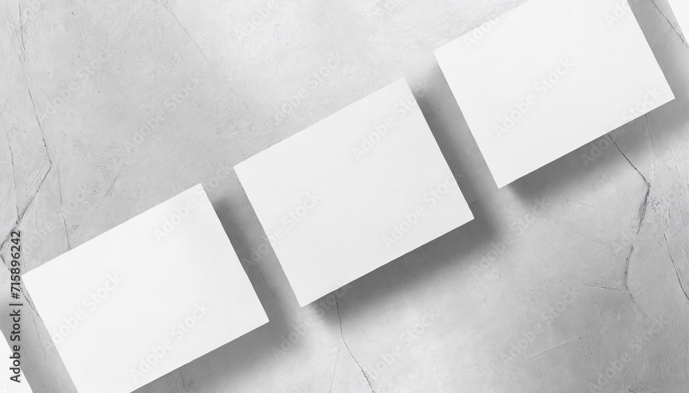 closeup of empty white rectangle poster mockups lying diagonally with ...