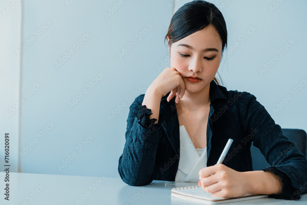 Beautiful young Asian woman writes letter on notebook while sitting at ...