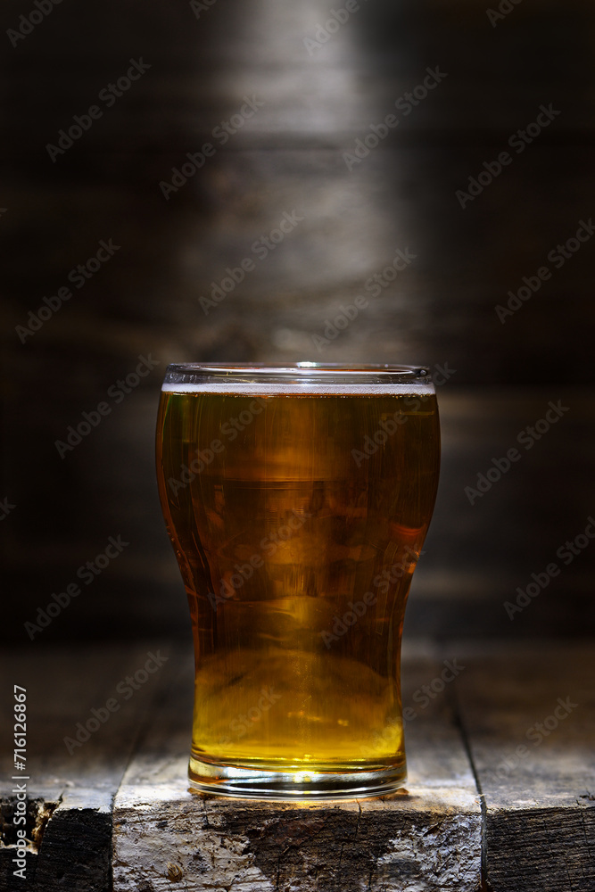 Glass of pale lager beer rustic wooden setting backlit spotlight mood ...