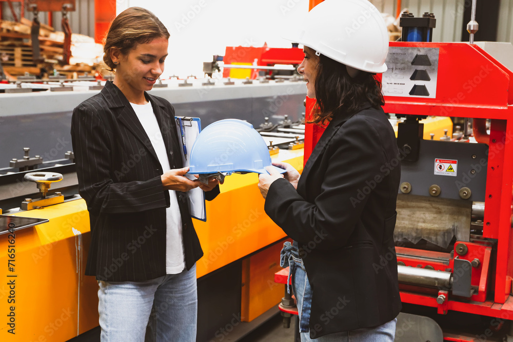 Foto Stock Female factory manager gladly handed over safety helmet ...