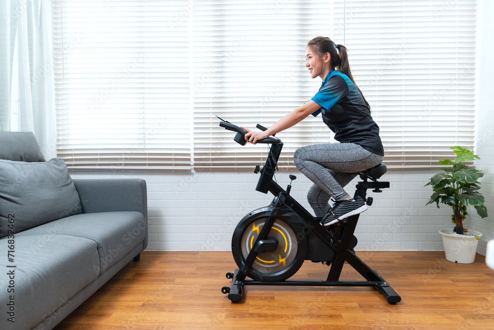 Asian female beautiful women cycle at home using stationary exercise ...