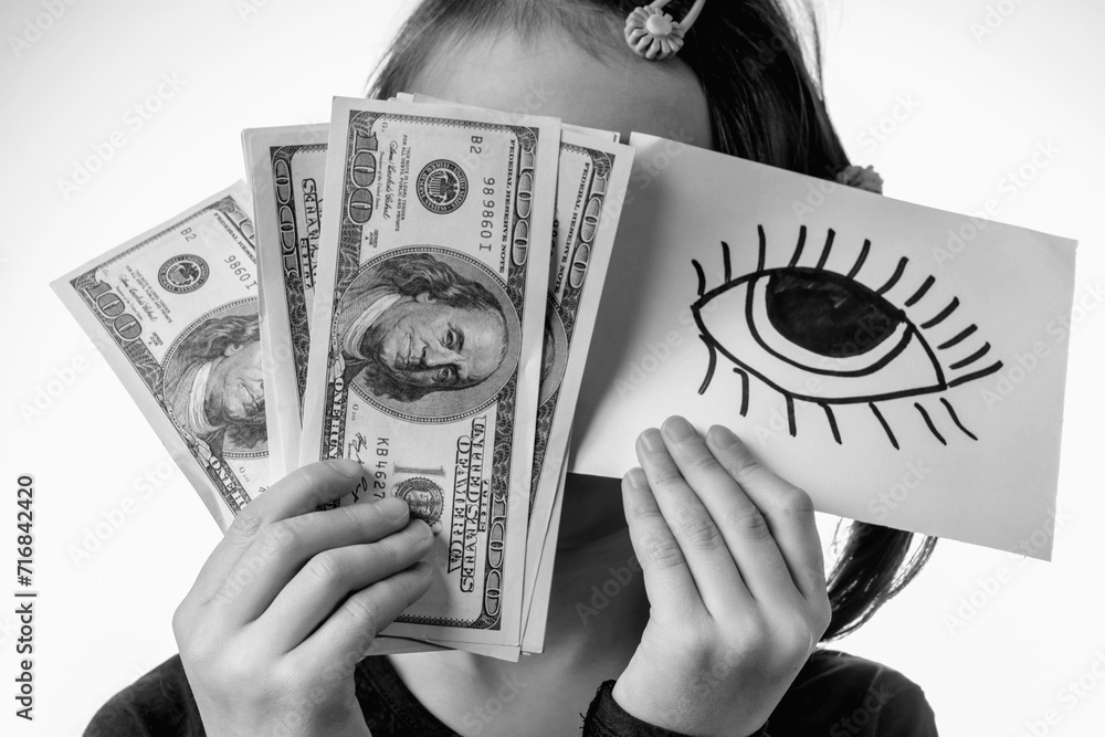 Conceptual photography: double standards. A young girl is holding US ...