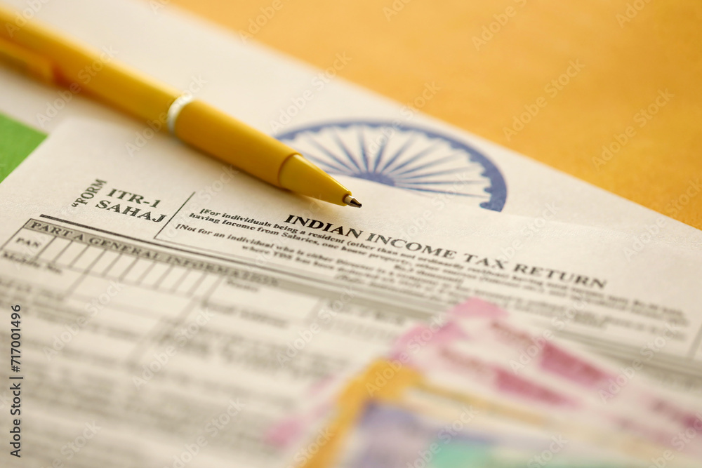 Indian income tax return blank form with pen and indian rupees bills on ...