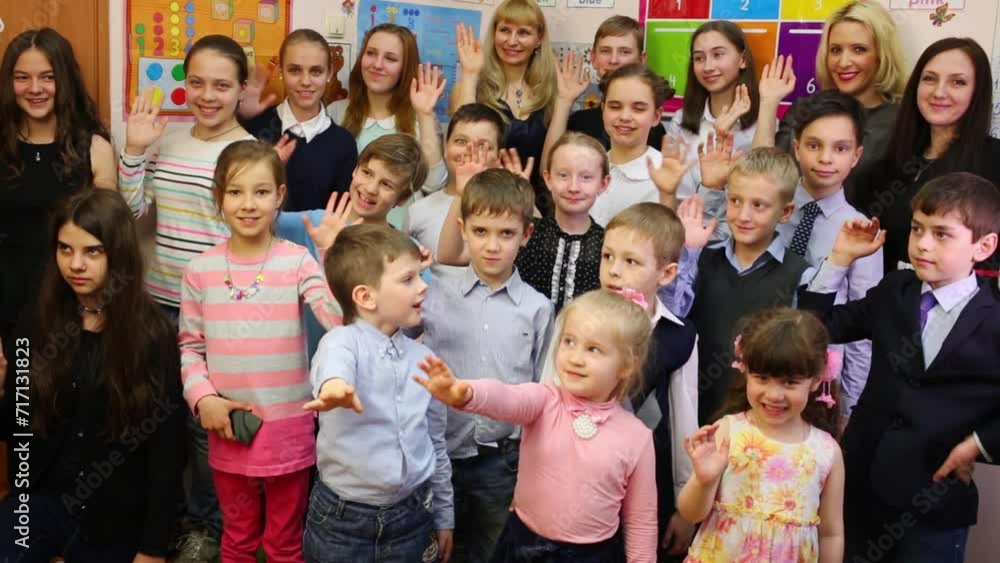 Twenty children of all ages and three women waving their hands Stock ...