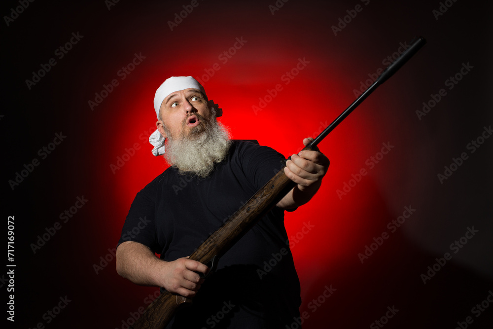 A gray-haired old man With a rifle in his hands looks up in fear he was ...