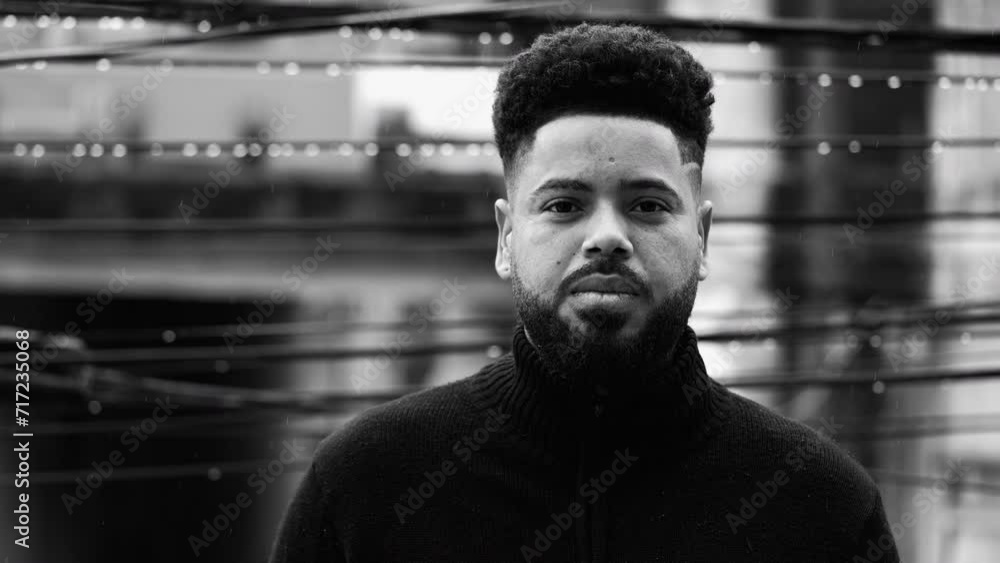 Solemn expression of a young South American black man standing in urban ...