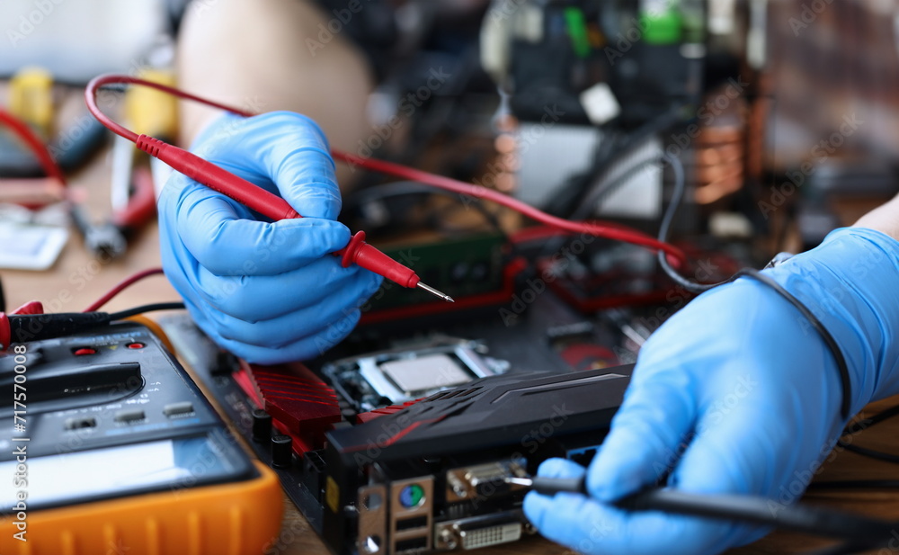 Gloved hands, on table repair an electronic device. Diagnosis device ...
