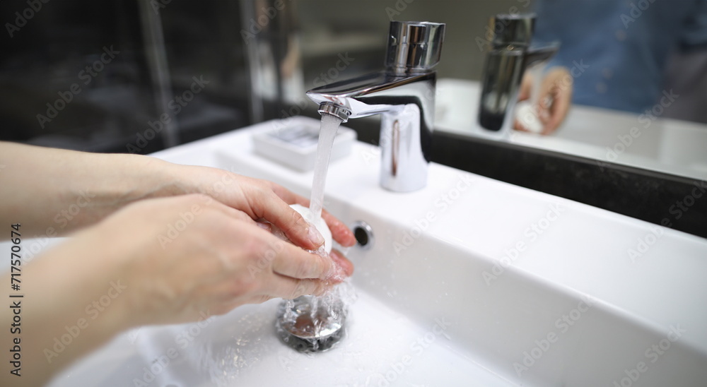 Man thoroughly washes his hands with soap under tap. Disposable hand ...