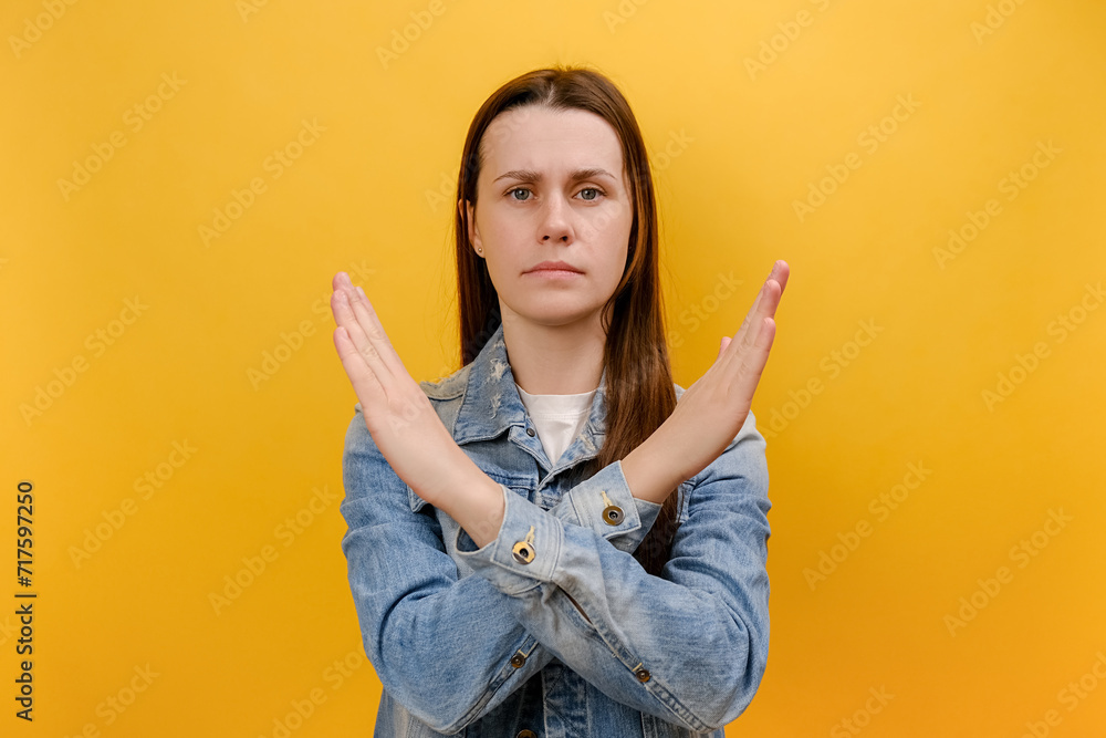 Portrait of serious young woman crossing hands, showing x sign, stop ...