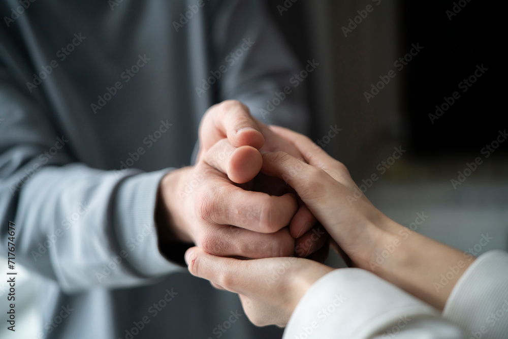 Two people engage in a compassionate touch, offering emotional support ...