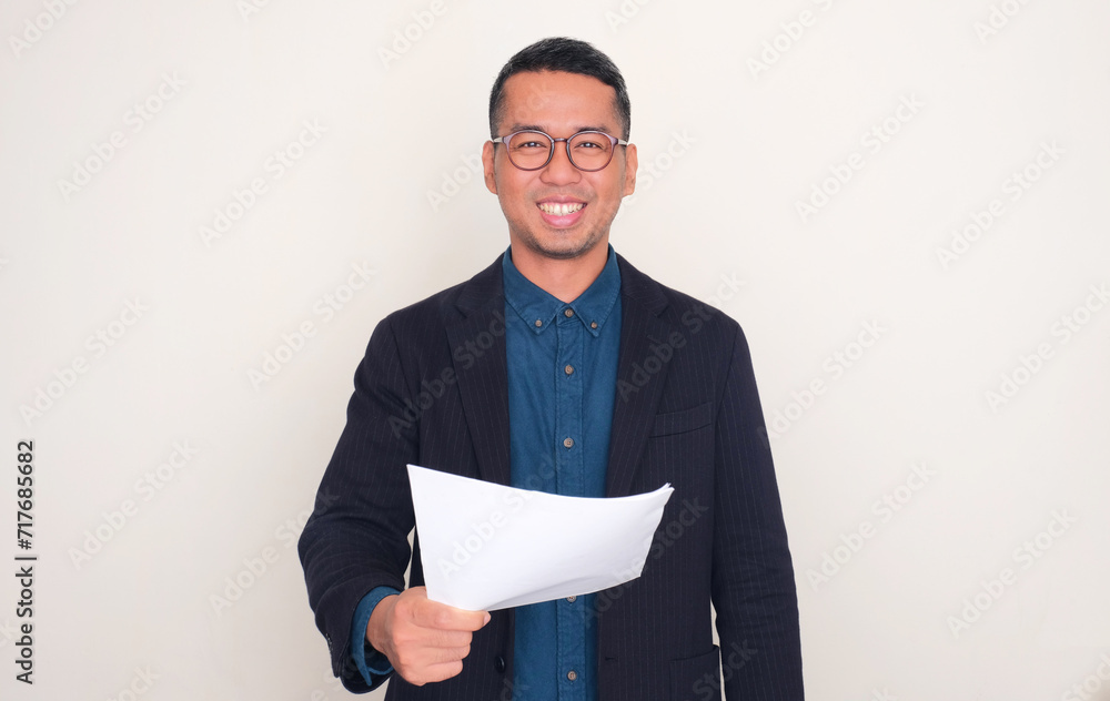 Asian businessman smiling confident at the camera while giving a paper ...
