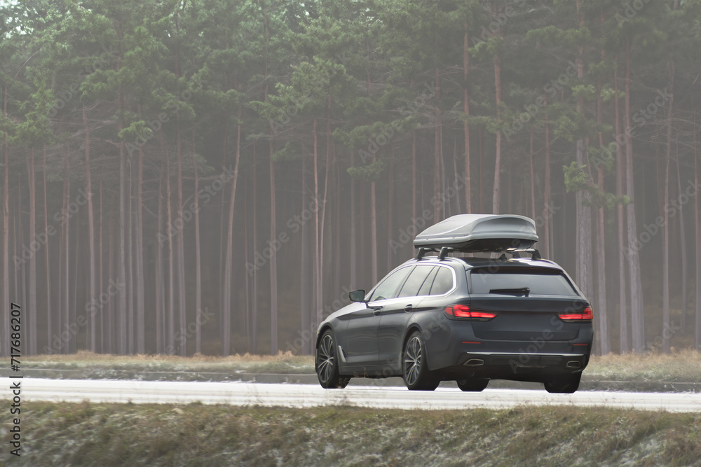 Rear side view of a car with a roof box. Black luggage compartment box ...