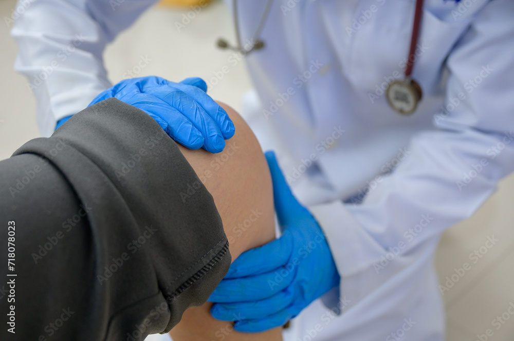 Doctor examining the knee of a woman who has a knee injury Knee joint ...