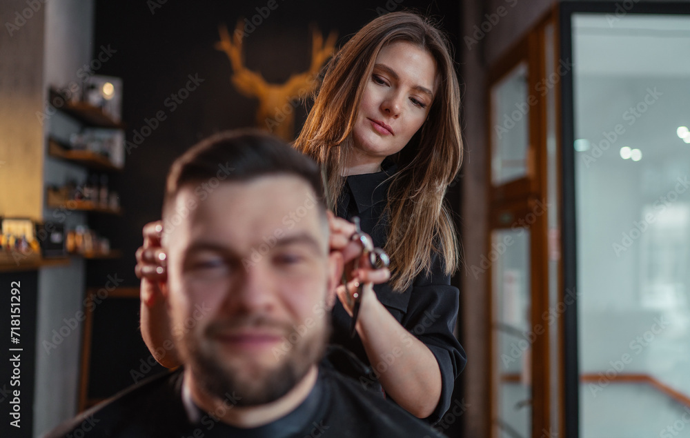 Young female barber portrait she gently making undercut hairstyle for ...