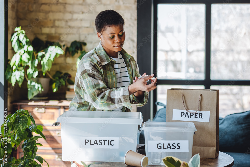 Young university student is managing waste sorting at home, smiling ...