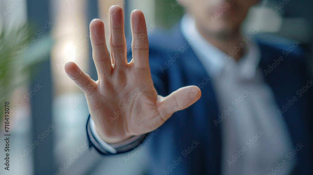 A close-up of a businessman's hand signaling 'stop', indicating a ...