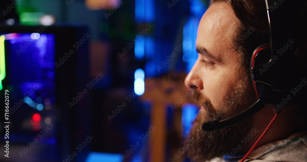 Pro gamer at home talking with teammates using headphones mic ...