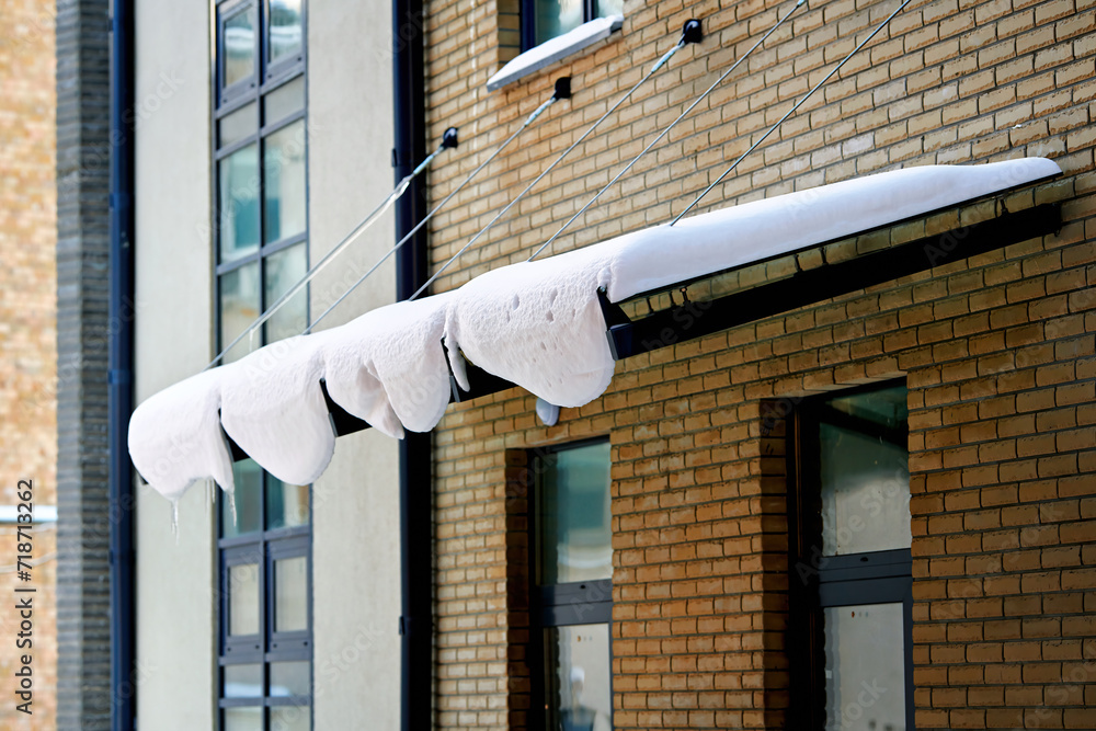 Door canopy with snow and ice, danger for pedestrians. Glass panel ...