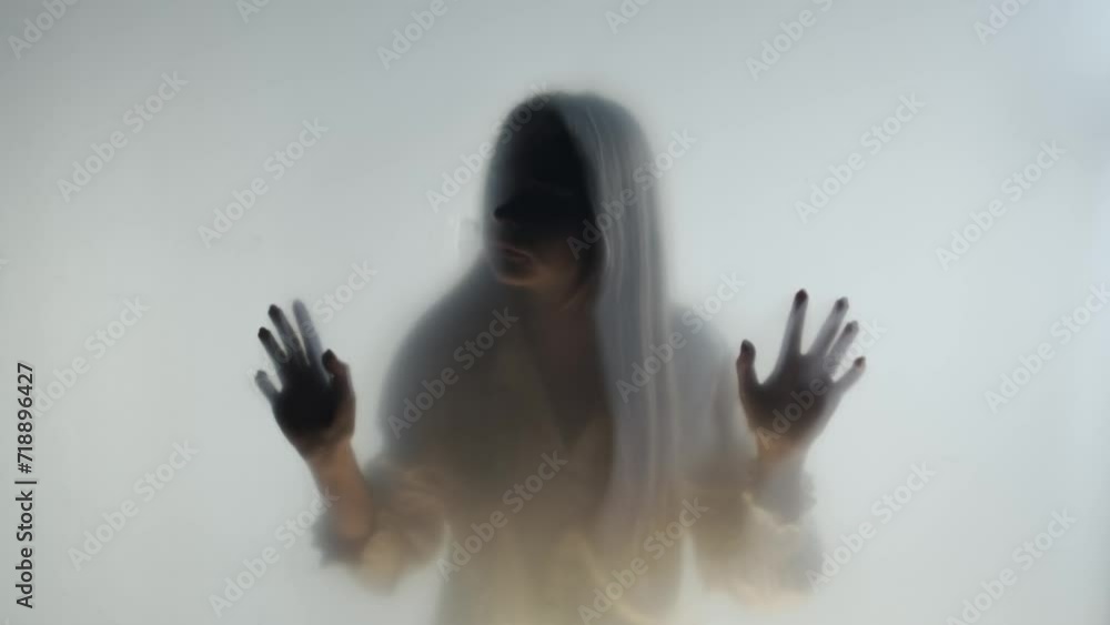 Silhouette of a woman behind a frosted glass or curtain in the fog. The ...