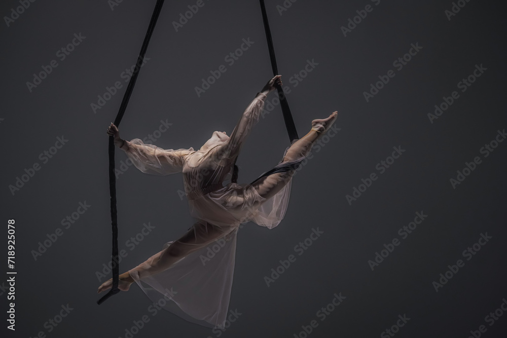 Girl aerial gymnast demonstrates stretching in twine on acrobatic ...