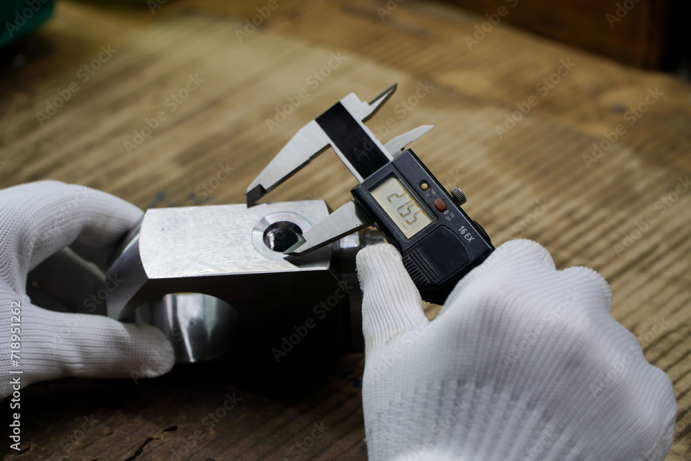 Technicians measure the diameter of the workpiece in the factory ...
