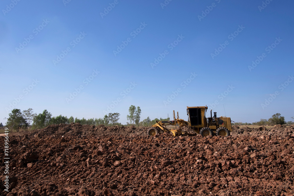 Road grader is pushing dirt. Motor grader is working,smoothing gravel ...