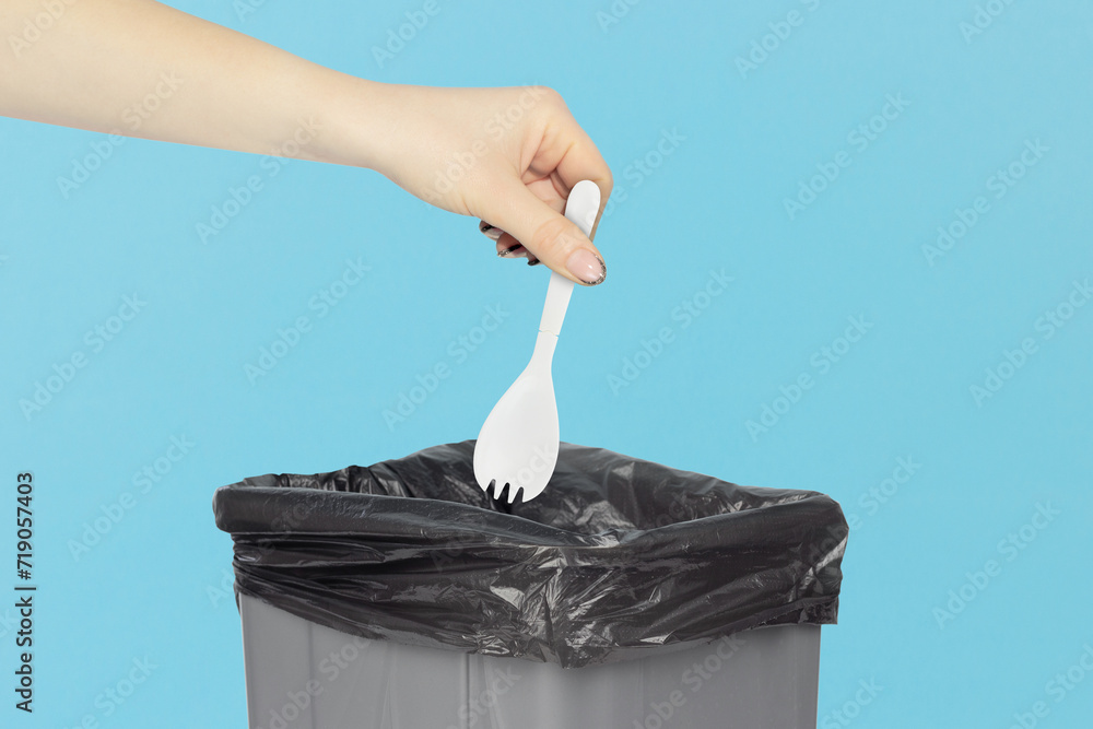 throw a plastic fork into the trash, disposable fork in hand in front ...