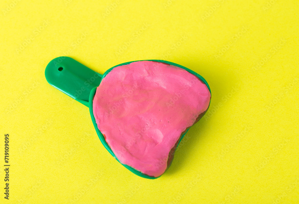 Green dental tray with alginate plastic mass for taking an impression ...