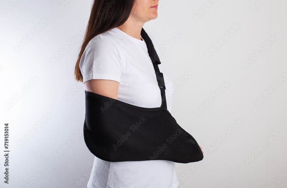 A girl in white with a fixing black bandage on her arm after an injury ...