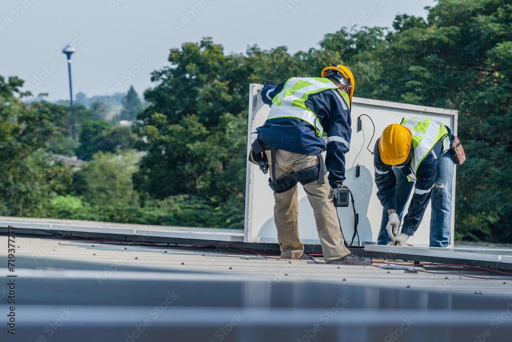 Worker Technicians are working to construct solar panels system on roof ...