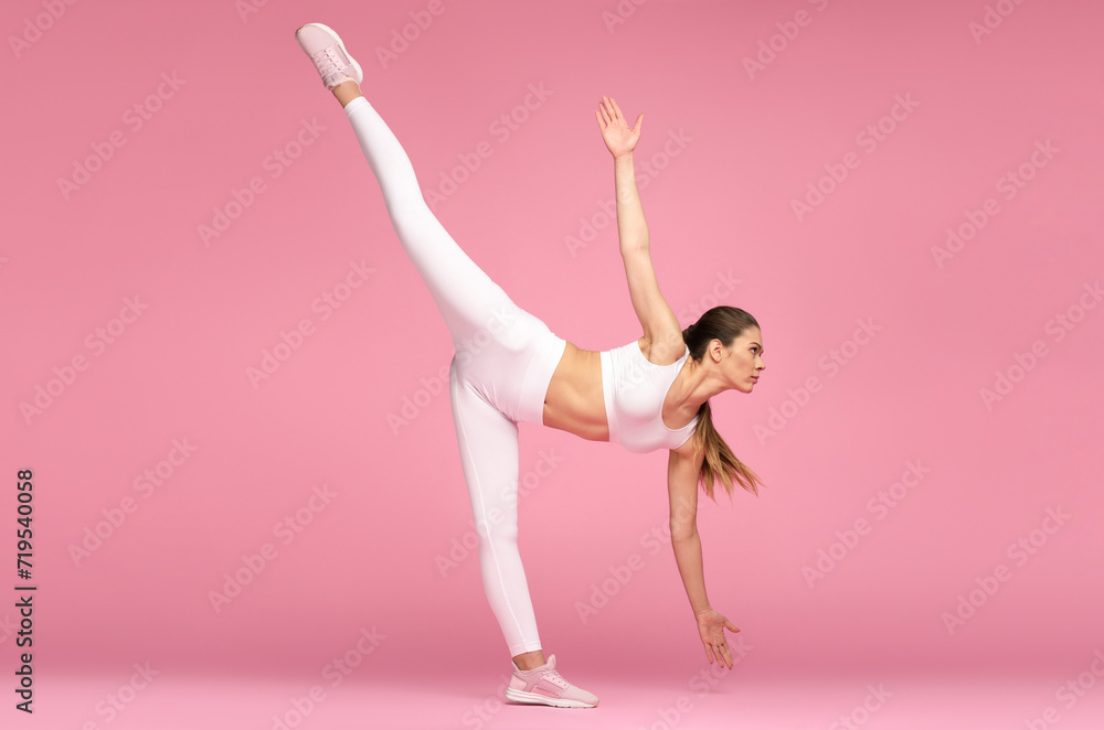 Side view of flexible athlete young woman in standing splits pose ...