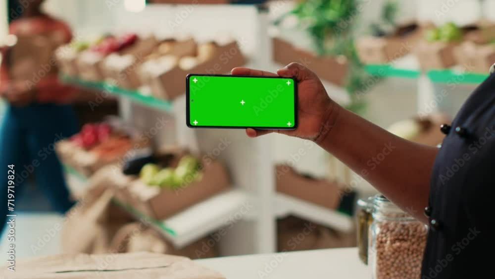 African american owner using greenscreen display at checkout, holding ...