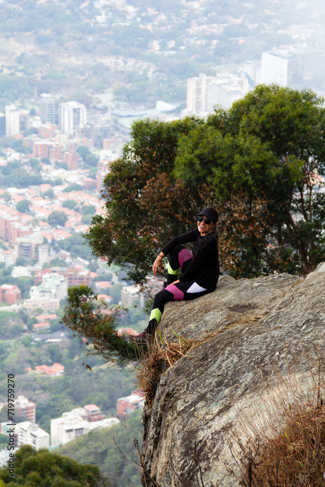 hiking woman laying down on edge of big stone in the mountain. view of ...