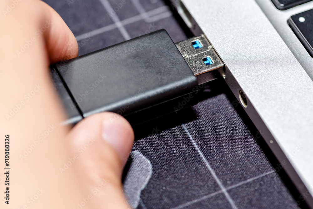 Hand inserting Hardware Wallet plugged into a computer laptop, Hand inserting USB flash memory ...