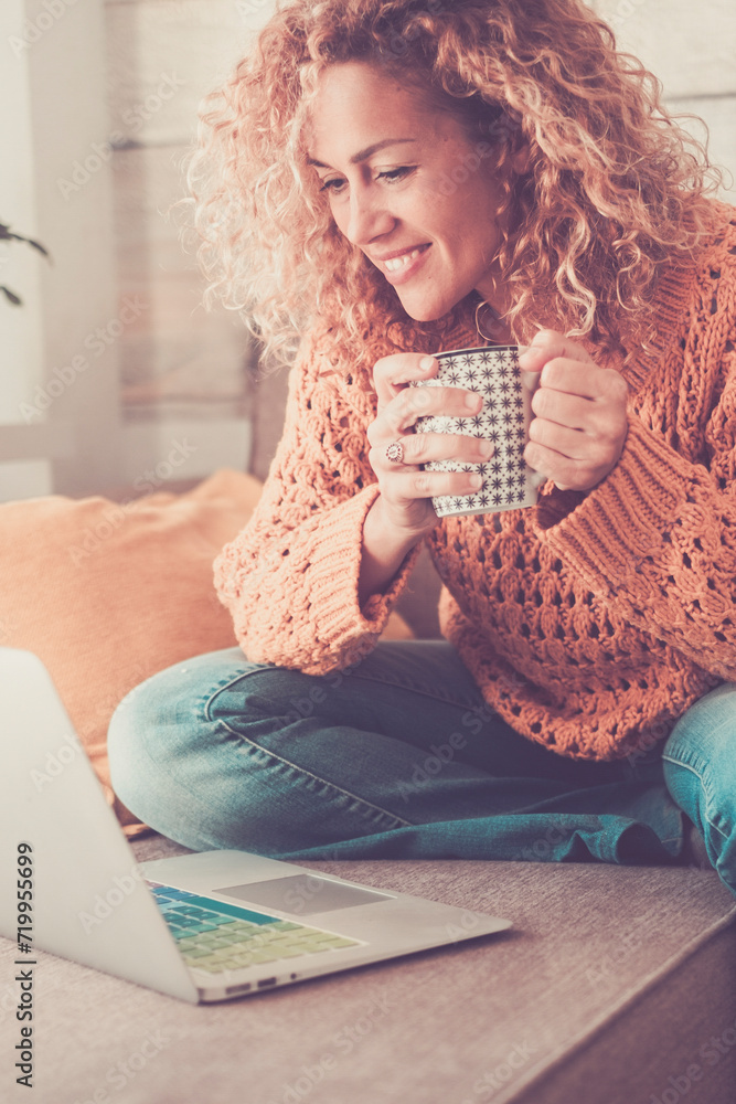 Cheerful independent adult beautiful woman work and use laptop computer ...
