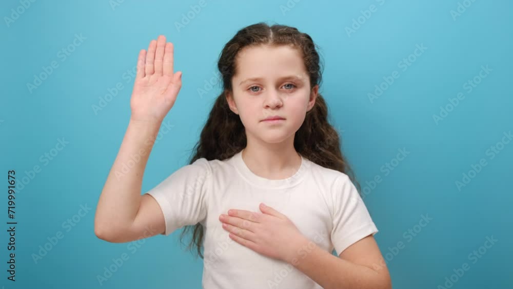 Portrait of serious preteen girl child raising her palm to take oath ...