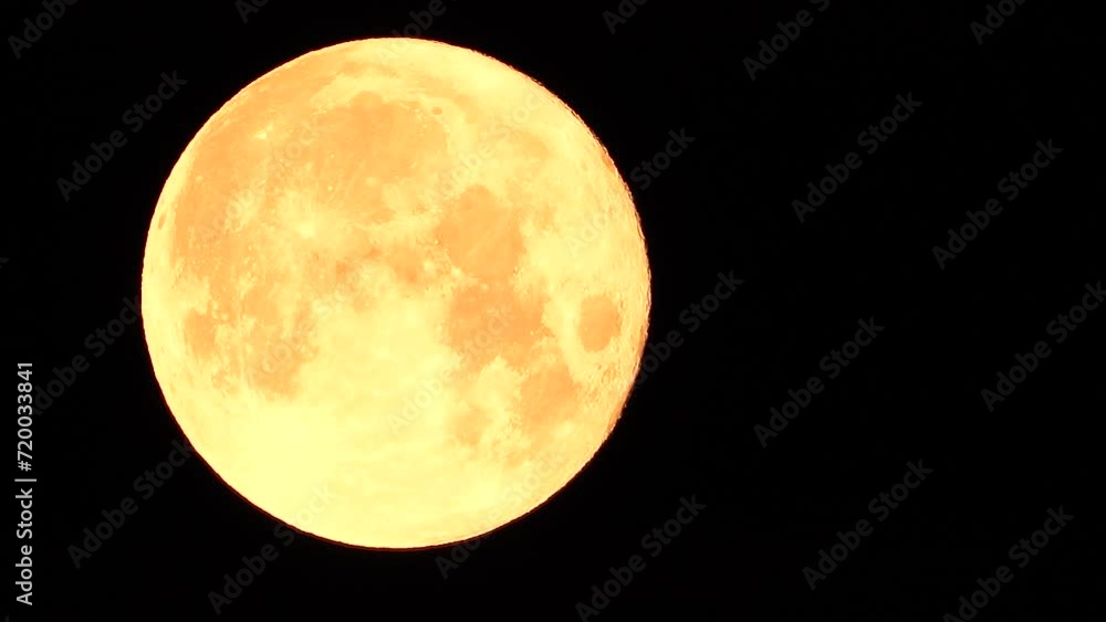 A glowing golden huge full moon seen from earth through the atmosphere ...