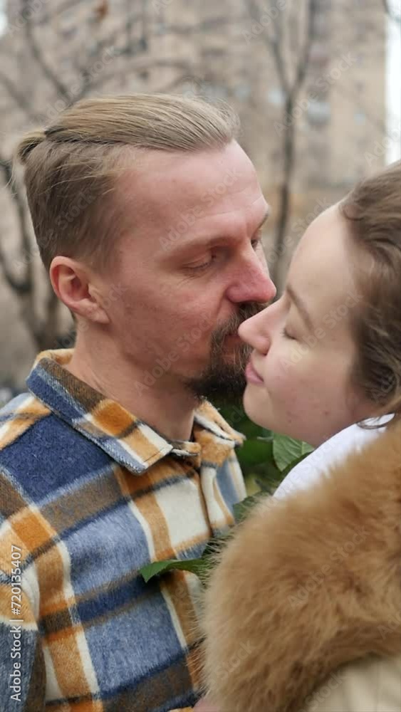 Vertical: a young man accepts a bouquet of roses as a gift from his ...