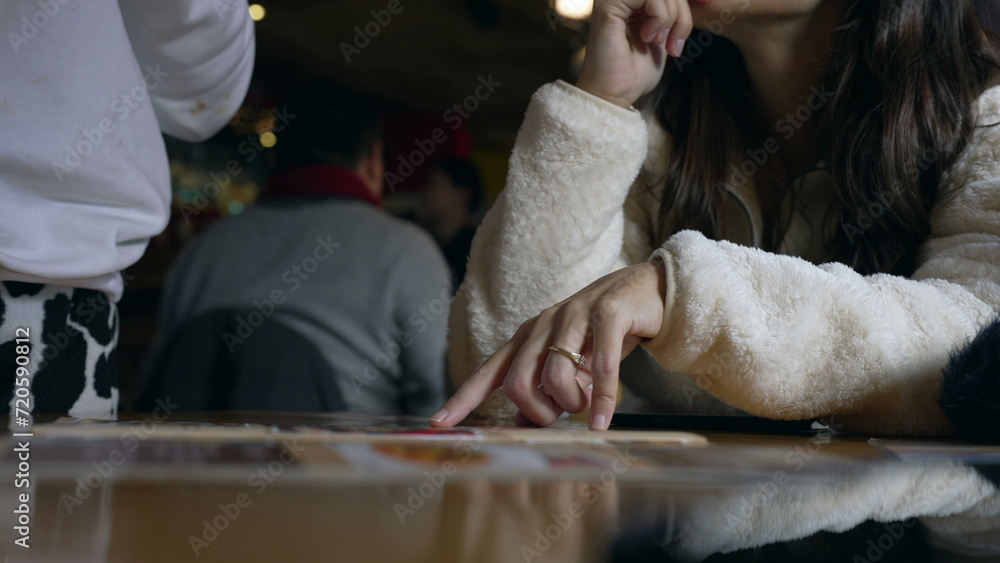 Woman's hand picking food from restaurant menu talking with waiter and ...