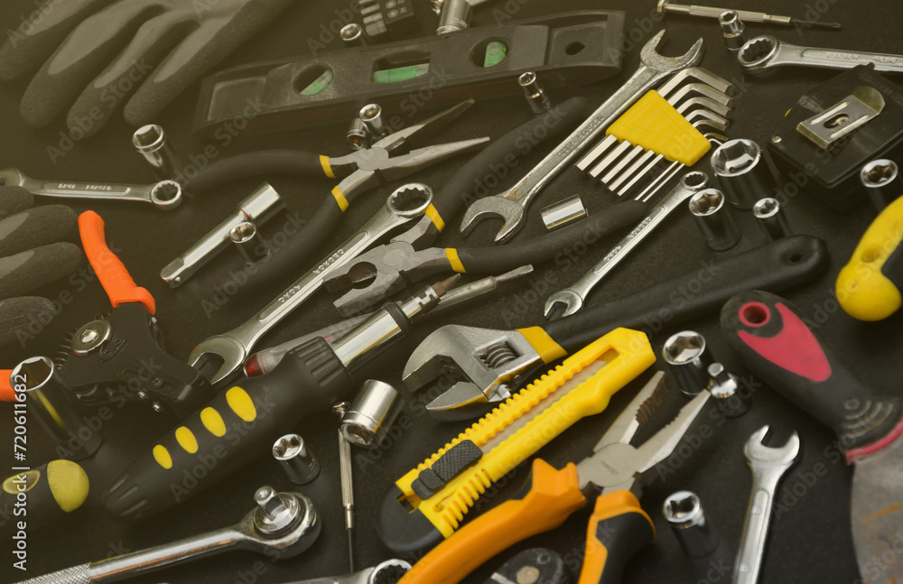 Handyman tool kit on black wooden table. Many wrenches and screwdrivers ...