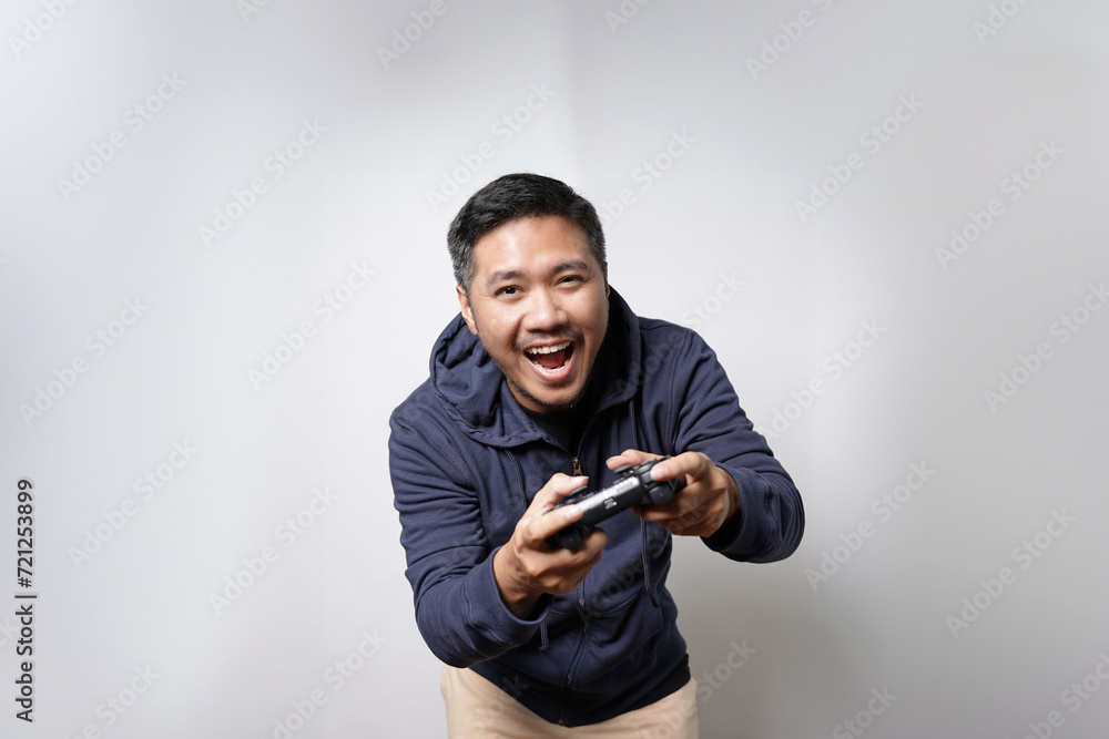 Male gamer with a joystick in his hand who is happy over victory in a ...