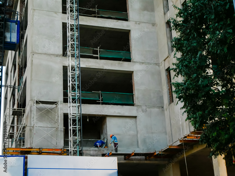 Construction worker at concrete building high ceiling high-rise ...