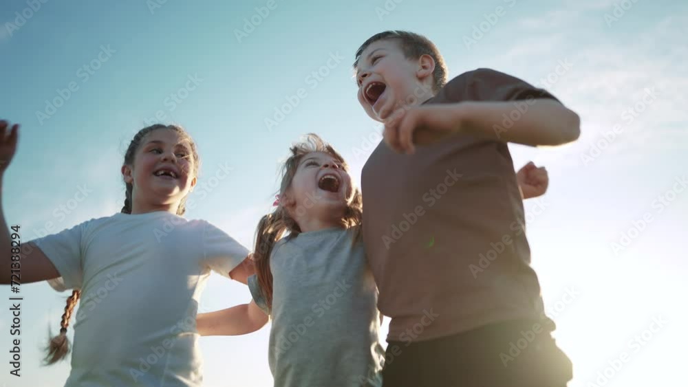 group of kids team hugging a jumping and rejoicing outdoors. happy ...