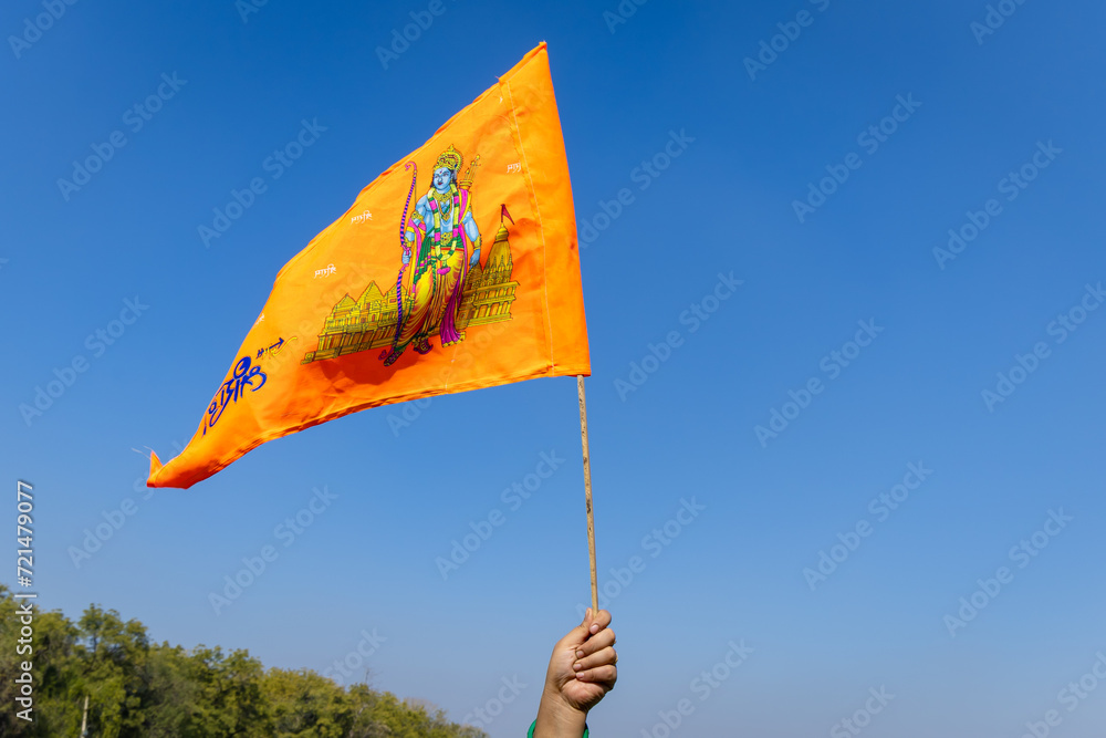 holy saffron flag with lord rama idol holing in hand with bright blue ...